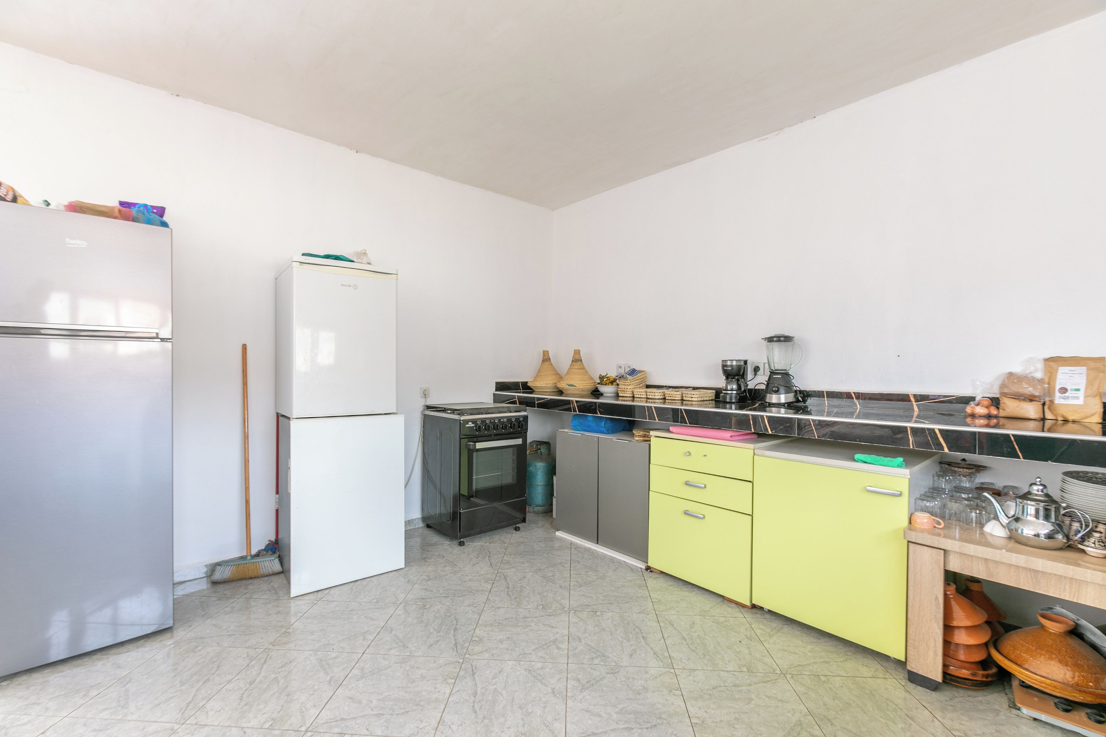 Uma cozinha com geladeira, forno e fogão.