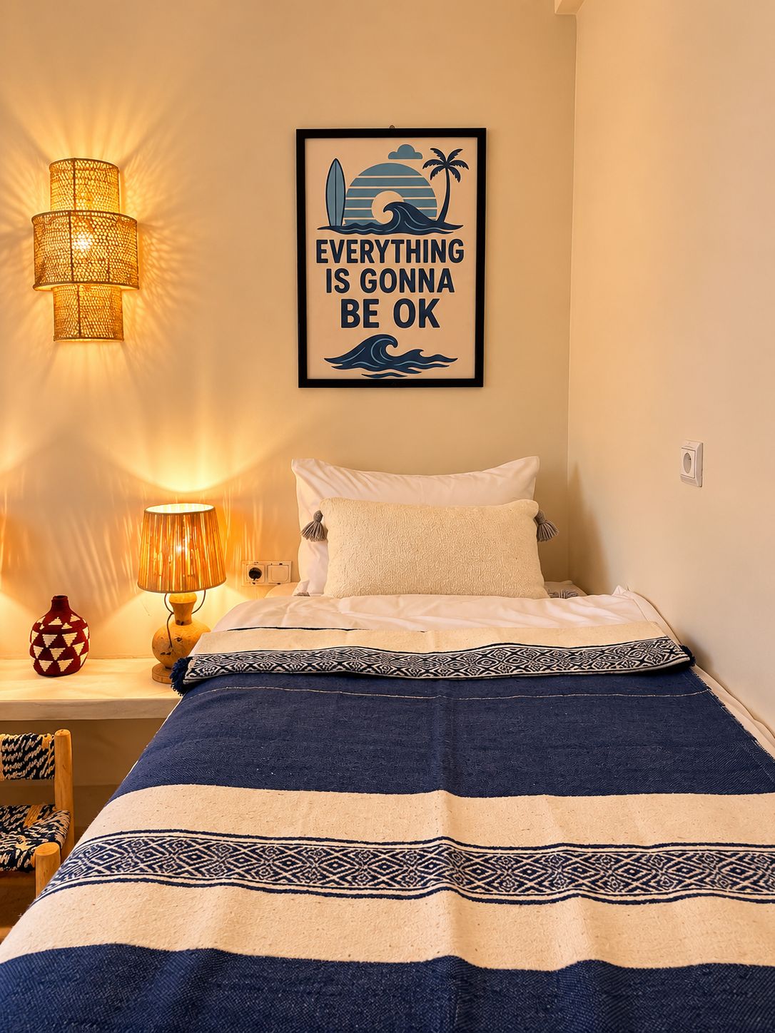 Quarto com cama, um quadro na parede, luminária e um vaso decorativo.