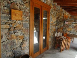 Parede de pedra com porta de madeira e placa indicando o número 3.