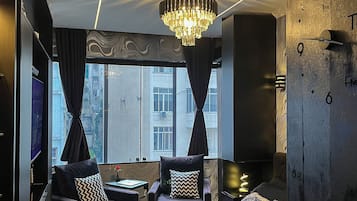 Quarto moderno com uma cama grande, um candelabro, vista para edifícios e um relógio na parede.