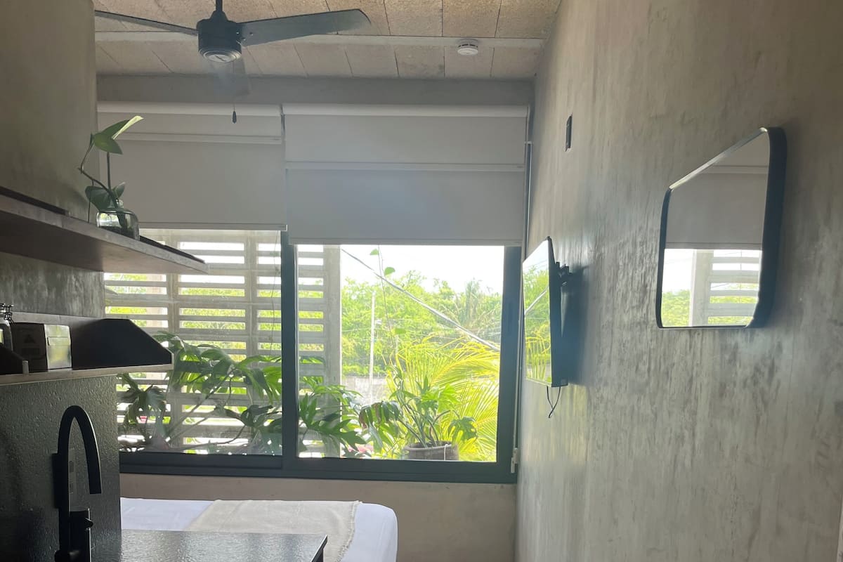 Casa de banho com lavatório, espelho e ventoinha no teto.