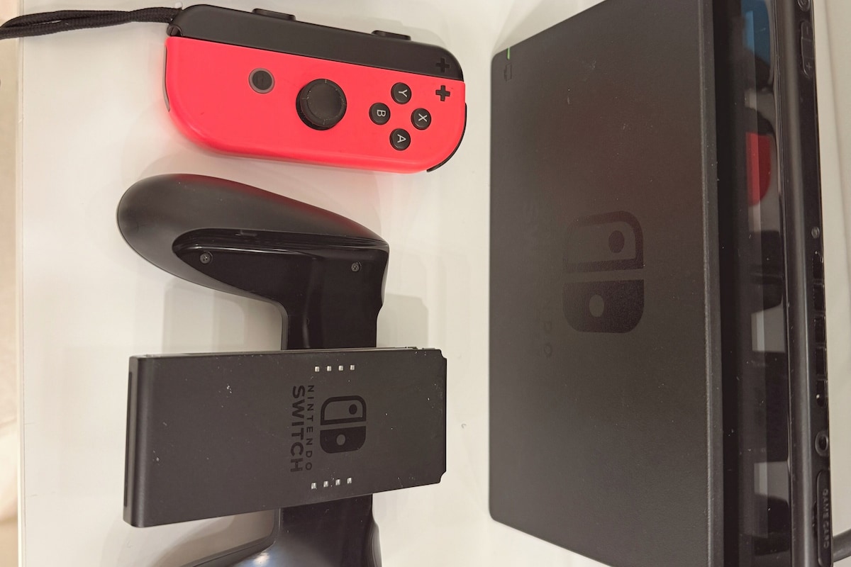Um console Nintendo Switch com dois controles e um dock de carregamento.