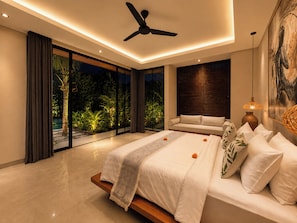 Quarto moderno com cama grande, ventilador de teto e vista para o exterior.