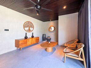 Um interior moderno com um armário de madeira, mesa redonda e cadeira de vime.