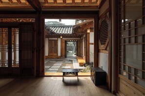 Um interior japonês tradicional com tatames, portas deslizantes e vista para o exterior.