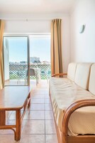 Uma varanda com sofá, mesa e cadeiras.