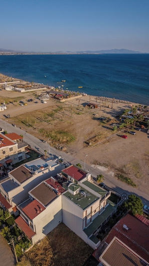 Vista aérea de uma área costeira com edifícios, praia e mar.