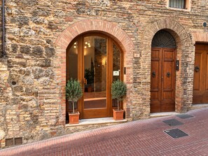 Um edifício de pedra com porta de madeira e entrada em arco.