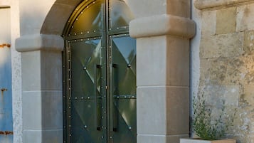 Um edifício com uma grande entrada em arco, degraus de pedra e um canteiro.