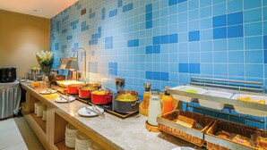 Disposição de buffet com diversos alimentos e utensílios de servir.