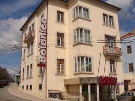 Um edifício de vários andares com uma placa na fachada que diz 'Botanico'.
