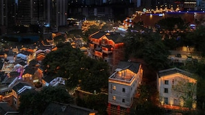 Um edifício tradicional com vários níveis e um pátio, rodeado por árvores e outros edifícios.