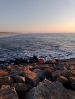 Uma costa rochosa com ondas quebrando nas pedras.