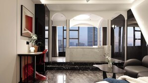 Interior moderno com piso de mármore, balcão de recepção, área de estar e grandes janelas com vista para a cidade.