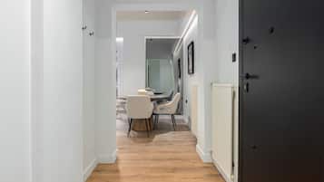 Corredor que dá para uma sala de jantar com mesa e cadeiras.