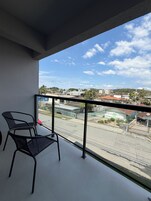 Uma varanda com vista para a paisagem urbana, incluindo edifícios e uma rua.