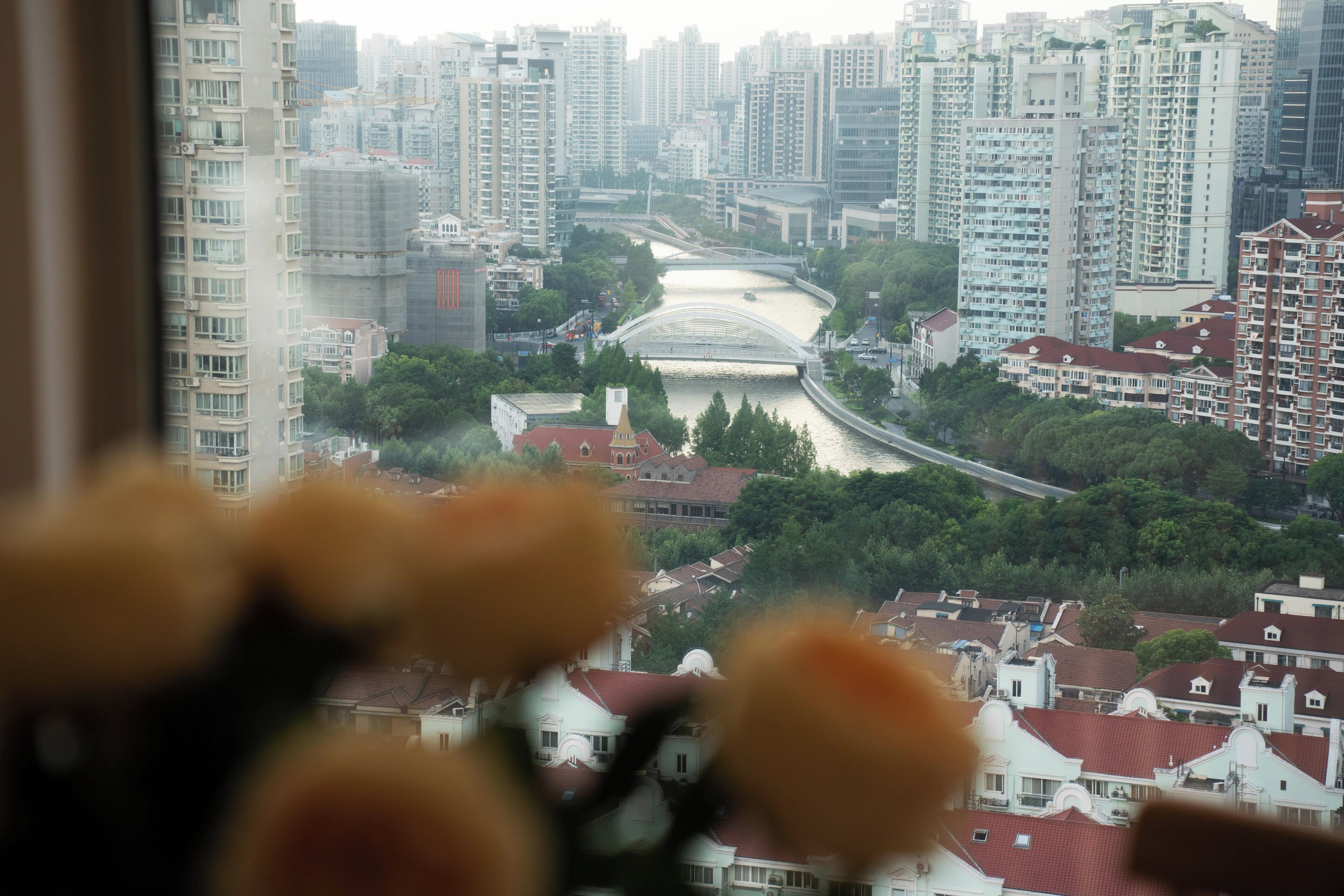 Vista de um horizonte urbano com edifícios altos, um rio e uma ponte.