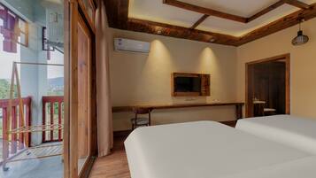 Quarto de hotel com varanda, cama, escrivaninha e janela.