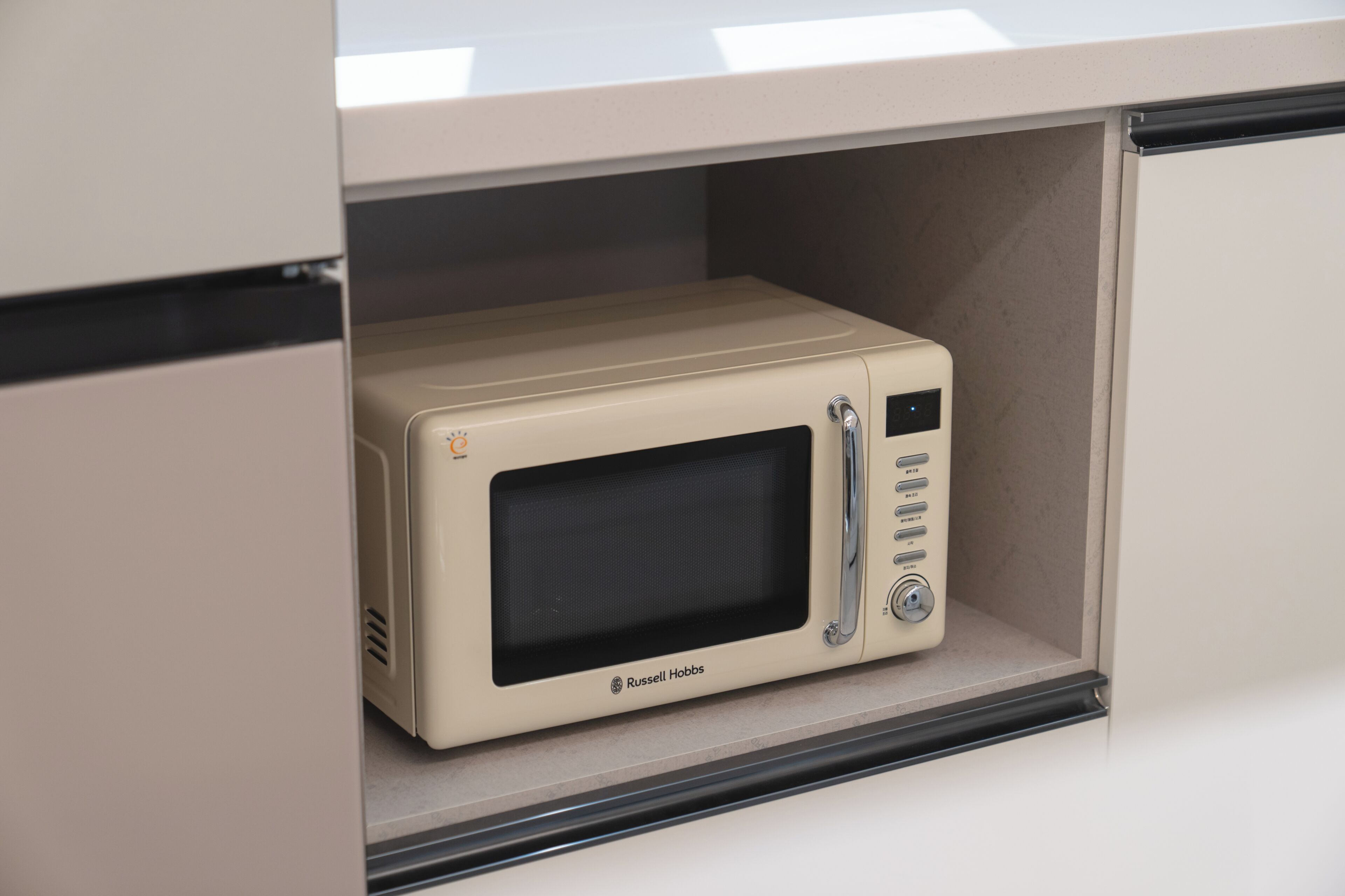 Forno de micro-ondas em um armário de cozinha.
