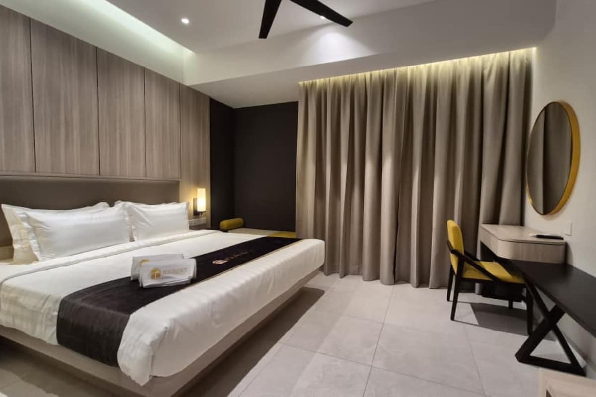 Quarto de hotel moderno com uma cama grande, uma escrivaninha e uma cadeira.