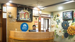 Uma receção com um logotipo, uma relíquia religiosa emoldurada e um mural floral.