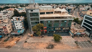 Um edifício com vários andares, teto plano, grandes janelas e um andar térreo comercial visível.