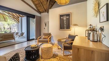 Uma sala de estar moderna com sofá, poltronas, mesa de centro e área de jantar.