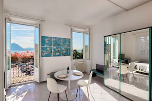 Um interior moderno com área de refeições, uma pintura e vista para o exterior.