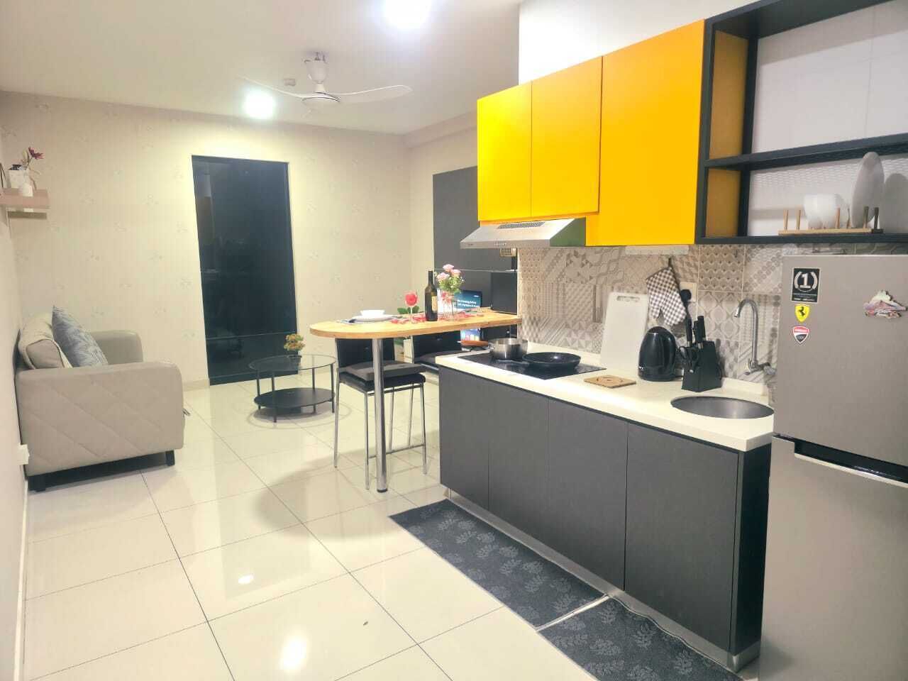 Uma cozinha moderna com uma ilha central, sala de jantar com mesa e cadeiras, e um sofá na sala de estar.