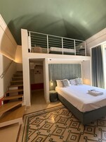 Um quarto com uma cama beliche, um lance de escadas e um tapete estampado.