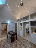 Um interior moderno com luminária no teto, ladrilhos com padrão e prateleiras embutidas.