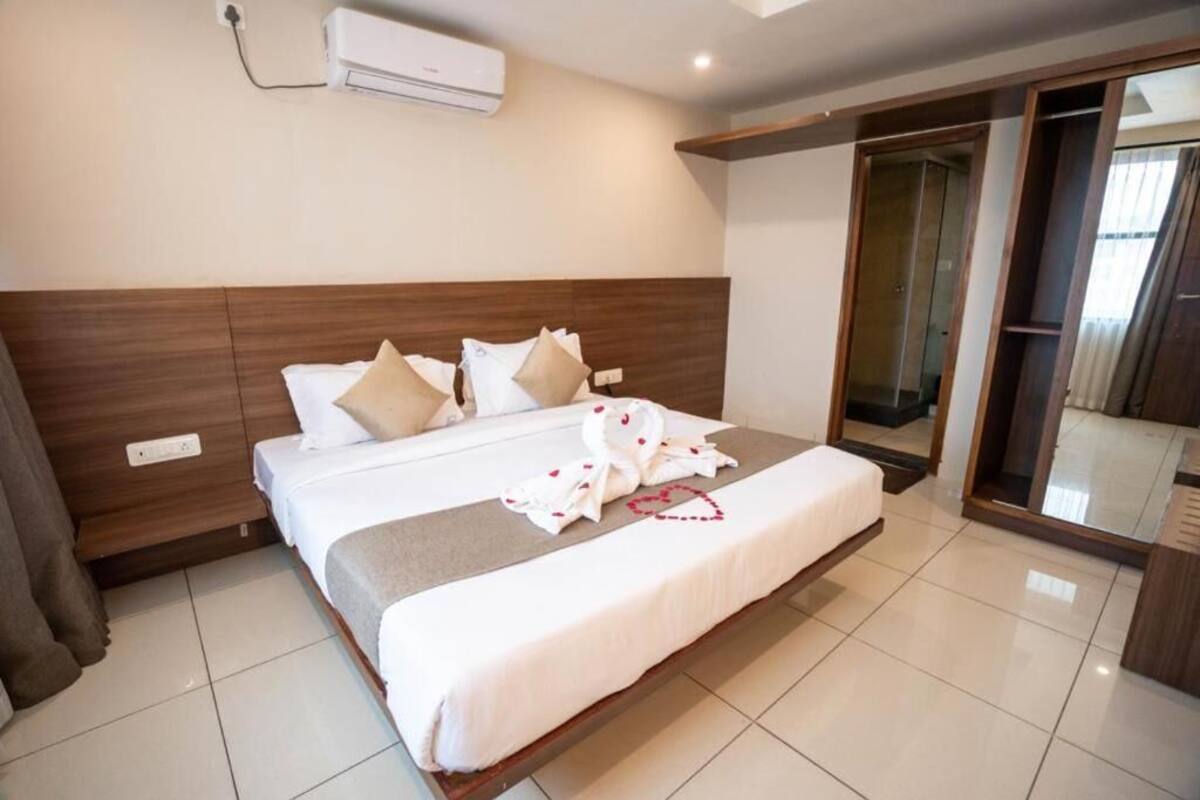Quarto de hotel com cama grande, guarda-roupa e ar condicionado.