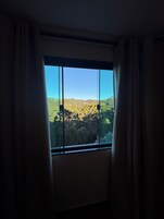 Uma janela com vista para uma paisagem arborizada.