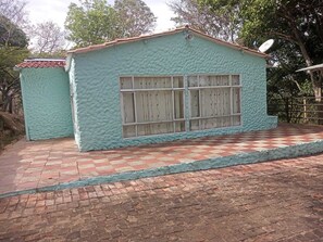 Um edifício com fachada texturizada, uma janela com padrão de grade e uma antena parabólica no telhado.