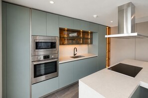 Uma cozinha moderna com eletrodomésticos embutidos, uma pia e bancada.