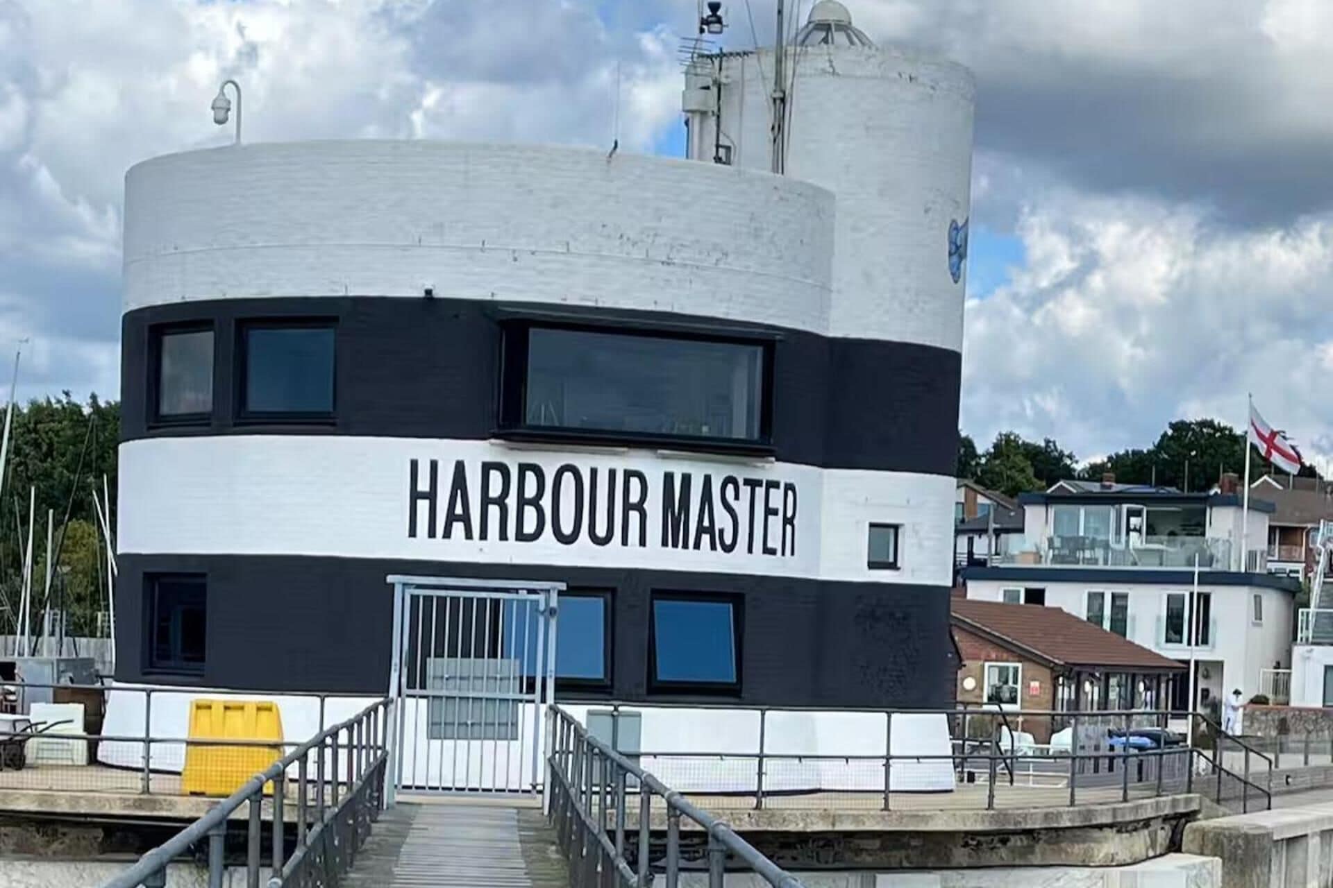 Um edifício de vários andares com uma placa de entrada que diz 'Harbour Master'.