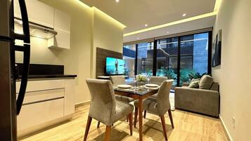 Cozinha moderna com área de refeições, TV e vista para o exterior.