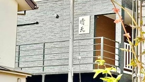 Um edifício com fachada texturizada e uma placa com caracteres japoneses.
