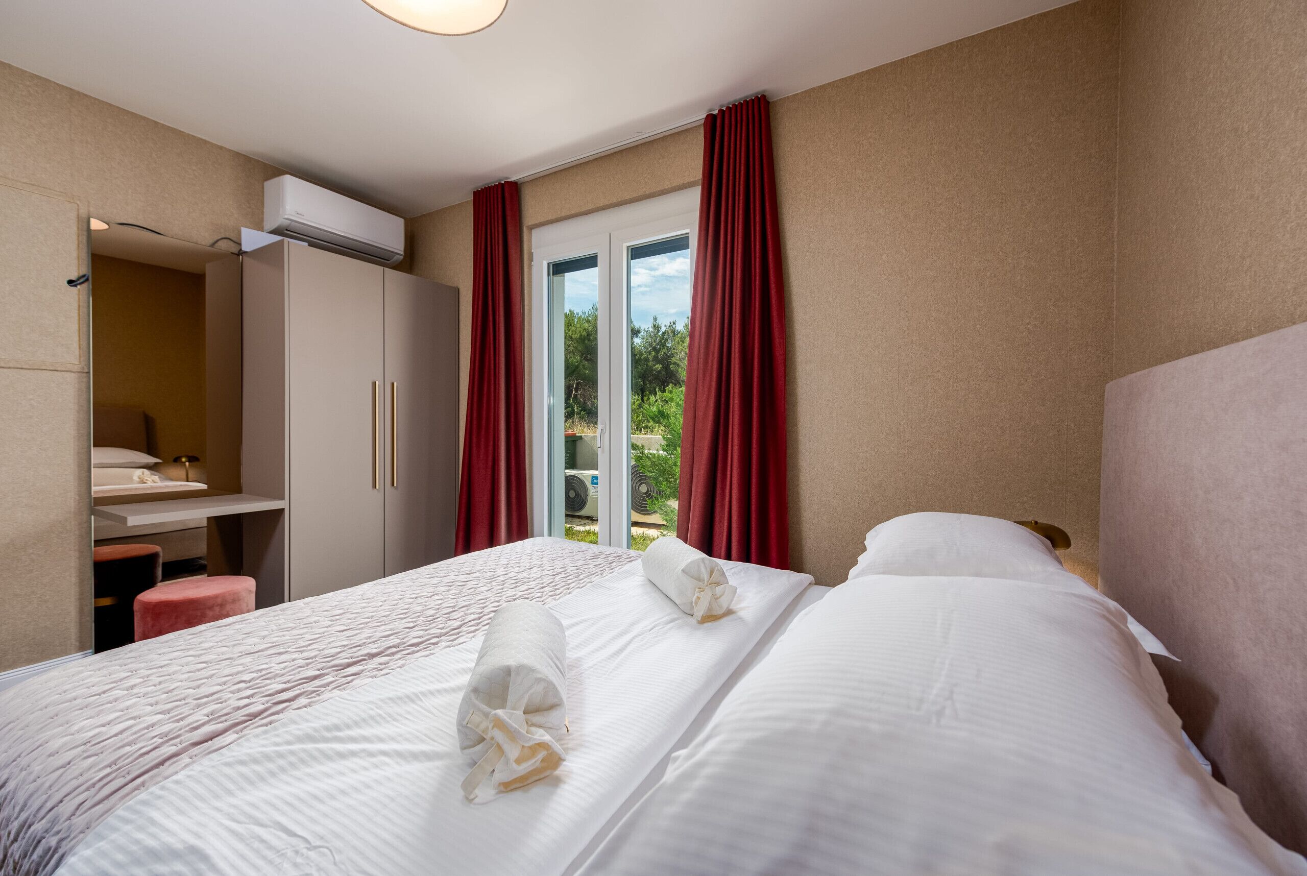 Quarto de hotel com cama, janela com cortinas, guarda-roupa e ar condicionado.