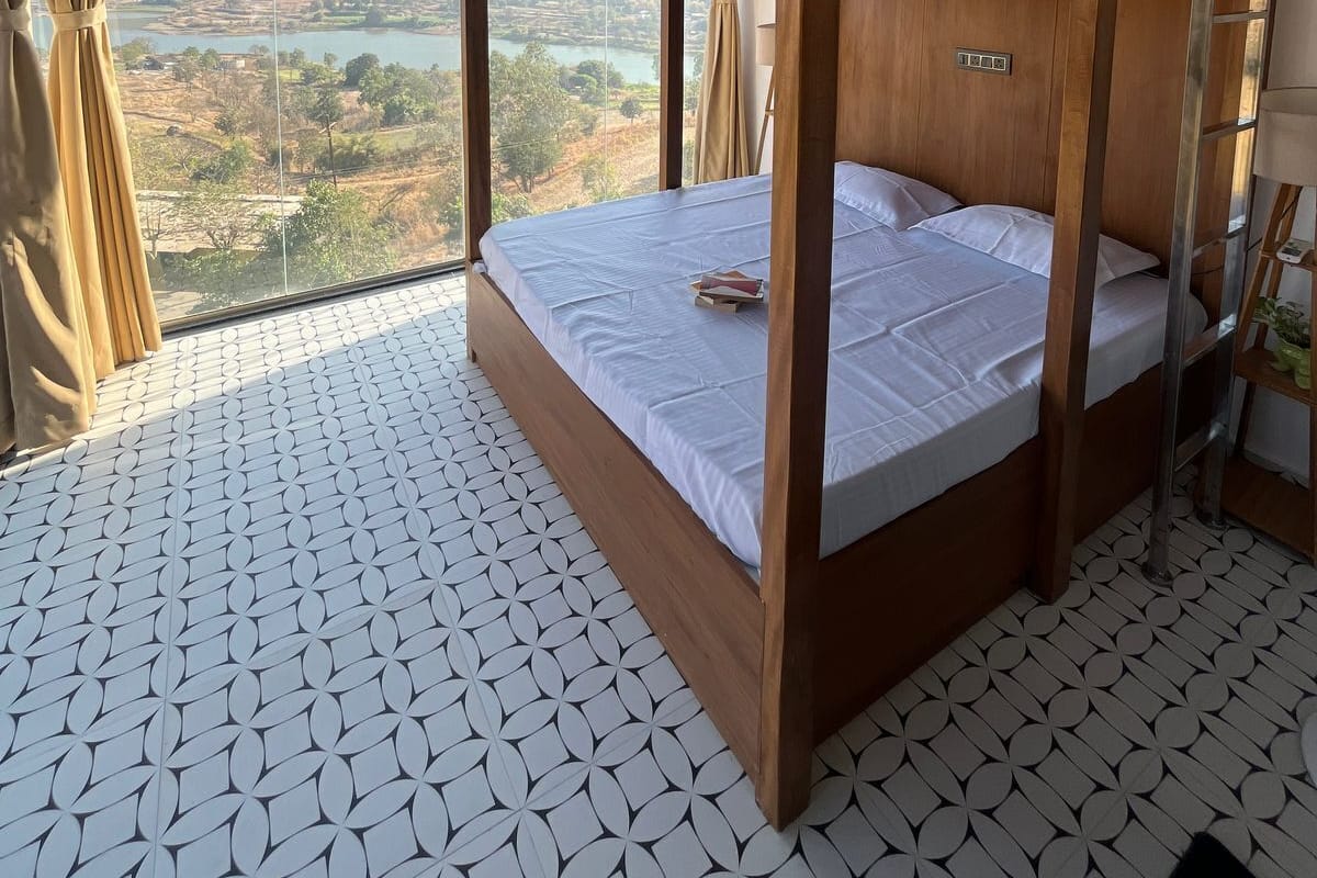 Quarto com beliche, ventilador, escada e vista para a paisagem.