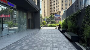 Um edifício moderno com fachada de vidro, um caminho pavimentado e uma placa da Mayfair Insurance.