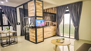 Uma sala de estar moderna com televisão, mesa de jantar e varanda com cortinas.
