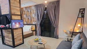 Uma sala de estar moderna com sofá, mesa de centro, televisão e uma parede com design em painel de madeira.