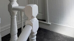 Uma porta branca com fechadura e interruptor de luz na parede.