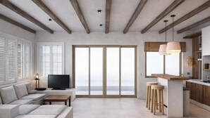 Uma sala de estar moderna com sofá, televisão e área de bar com banquetas.