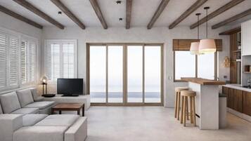 Uma sala de estar moderna com sofá, televisão e área de bar com banquetas.