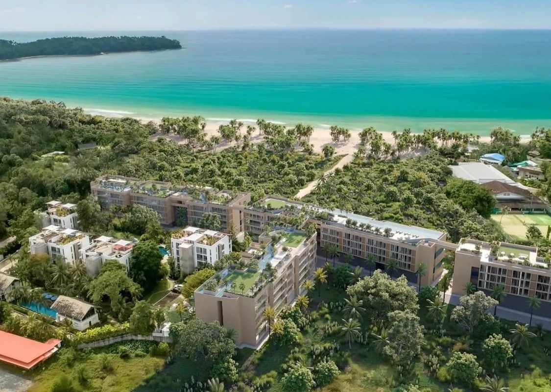 Resort costeiro com vários edifícios, uma praia e vista para o oceano.