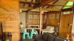 Um quarto rústico com uma cama, um sofá, uma mesa pequena e uma cadeira.