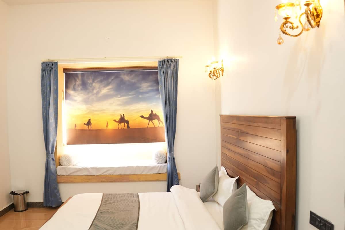 Quarto com cama, ventoinha no teto, mesa de cabeceira, luminária, janela com cortinas e luminária fixa na parede.