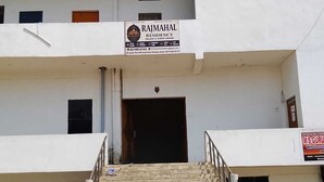 Um edifício de vários andares com uma placa indicando Rajmahal Residency.